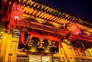 Um edifício tradicional com detalhes arquitetônicos elaborados e letreiros iluminados.