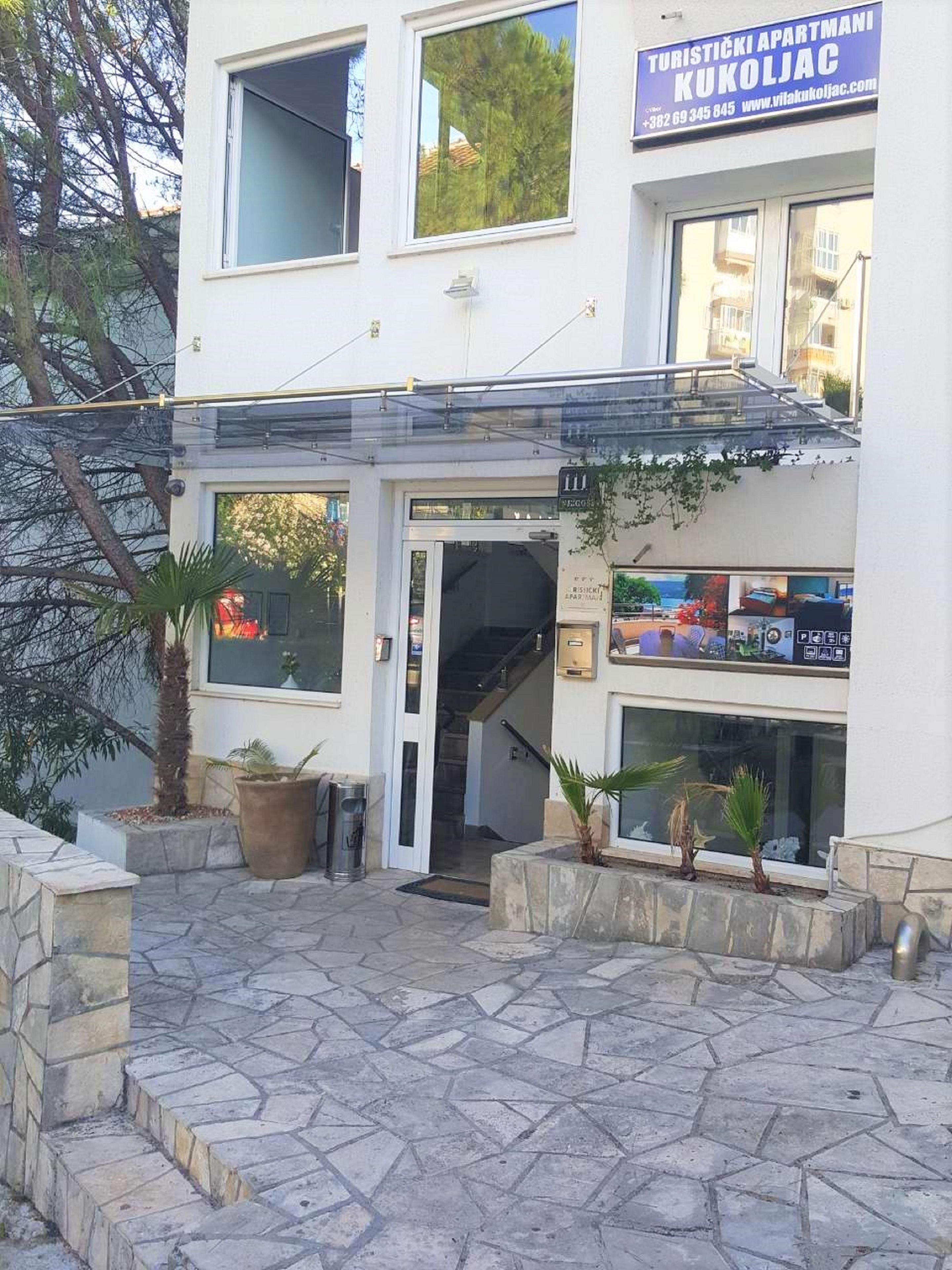 Um edifício de dois andares com uma placa indicando 'Turistički Apartmani Kukoljac'.