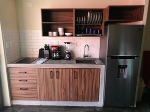 Um frigorífico/congelador grande, uma cafeteira/bule 