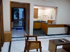 Um espaço de estar compacto com cozinha compacta, área de refeições e vista para o exterior.