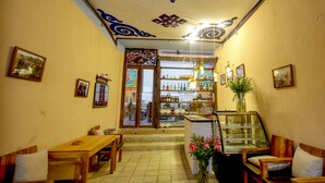 Um espaço de bar acolhedor com móveis de madeira, uma vitrine e um design de teto colorido.