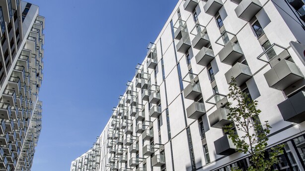 Um edifício moderno de vários andares com fachada em linhas retas e varandas.