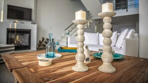 Mesa de madeira com dois castiçais e uma garrafa de vidro azul.