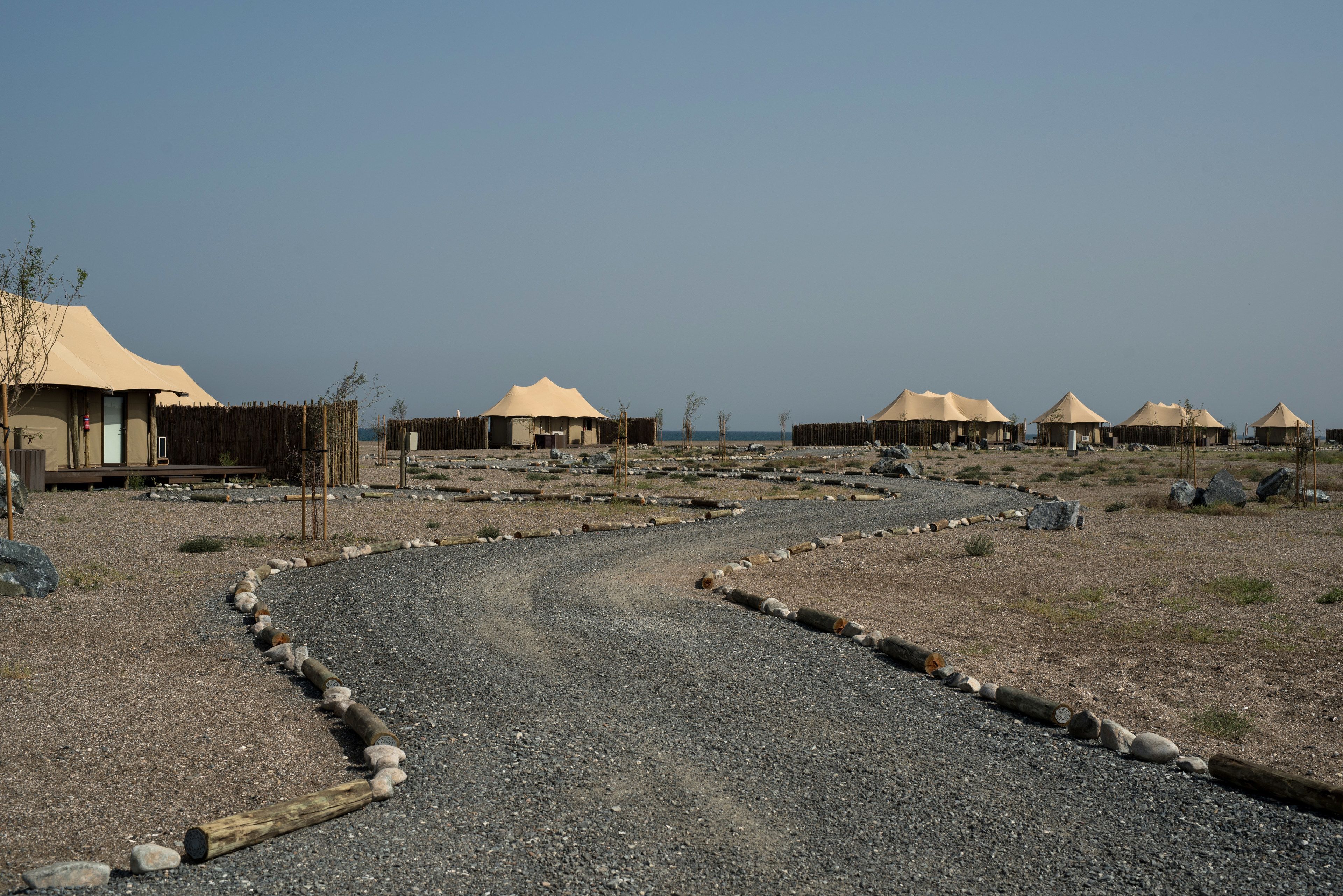 Um resort no deserto com várias tendas e uma estrada de cascalho.