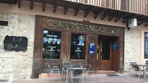 Um edifício rústico com fachada de madeira e uma placa com a inscrição 'Cerveceria Capri'.