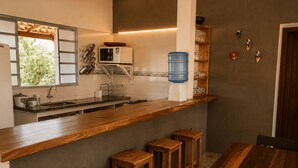 Um frigorífico, um micro-ondas, utensílios de cozinha 
