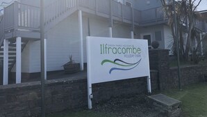 Um edifício com uma placa para Ilfracombe Holiday Park.