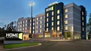 Um hotel com vários andares e uma placa com a inscrição HOME 2 SUITES BY HILTON.