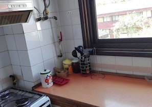 Um frigorífico/congelador grande, um micro-ondas, uma cafeteira/bule 