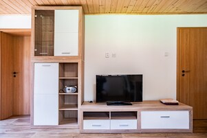 Quarto moderno com unidade de entretenimento em madeira, televisão de tela plana e prateleiras embutidas.