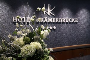 Placa de hotel com o nome 'HOTEL KRÄMERBRÜCKE' e um logotipo acima.