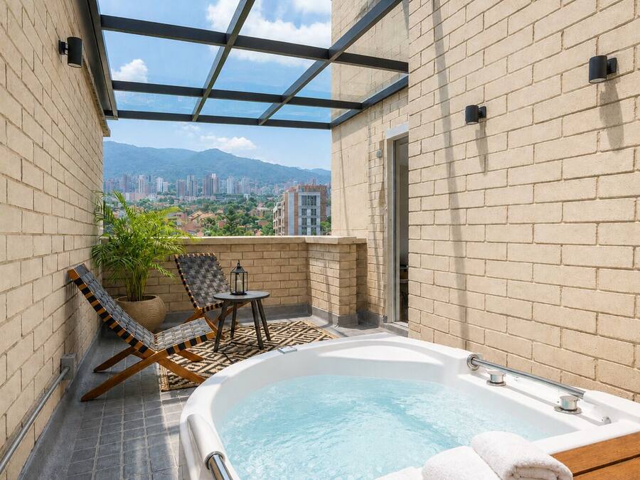 Terraço no telhado com hidromassagem, área de estar e vista para a paisagem urbana.