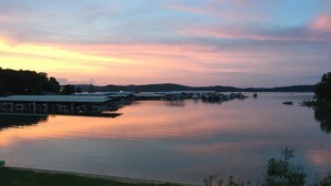 Um lago calmo ao entardecer, com cais e barcos.