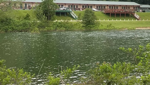 Uma pousada à beira do lago com um píer e terraço coberto.