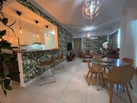 Um espaço de estar moderno com cozinha, sala de jantar e área de estar.
