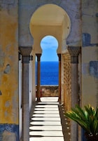 Um corredor com arcos que dá para a vista do mar.