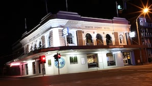 Hotel North Sydney com entrada destacada, uma placa e um canto de rua visível.