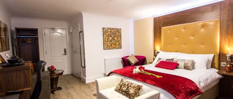Quarto de hotel com uma cama grande, uma mesa, uma cadeira e um guarda-roupa.