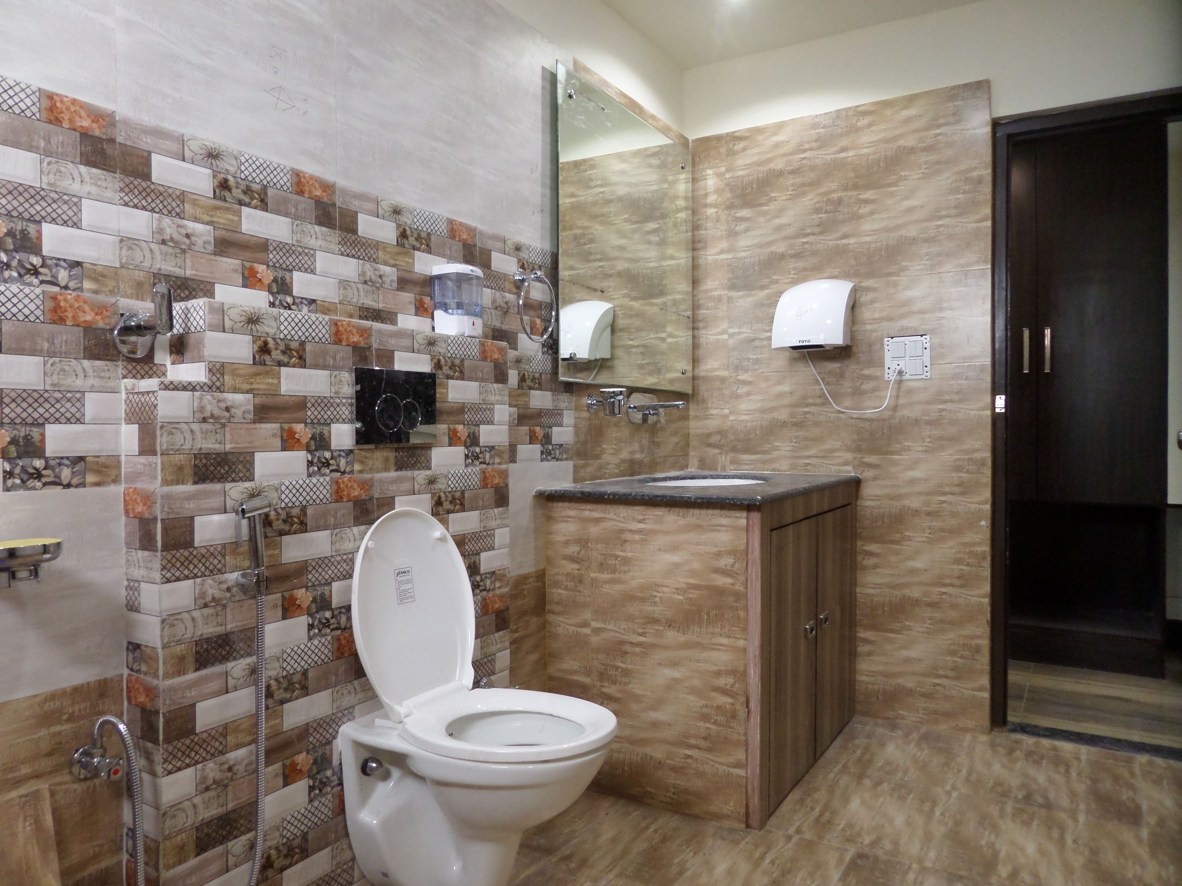 Casa de banho com painel de azulejos, sanita, lavatório e espelho.
