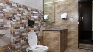 Casa de banho com painel de azulejos, sanita, lavatório e espelho.