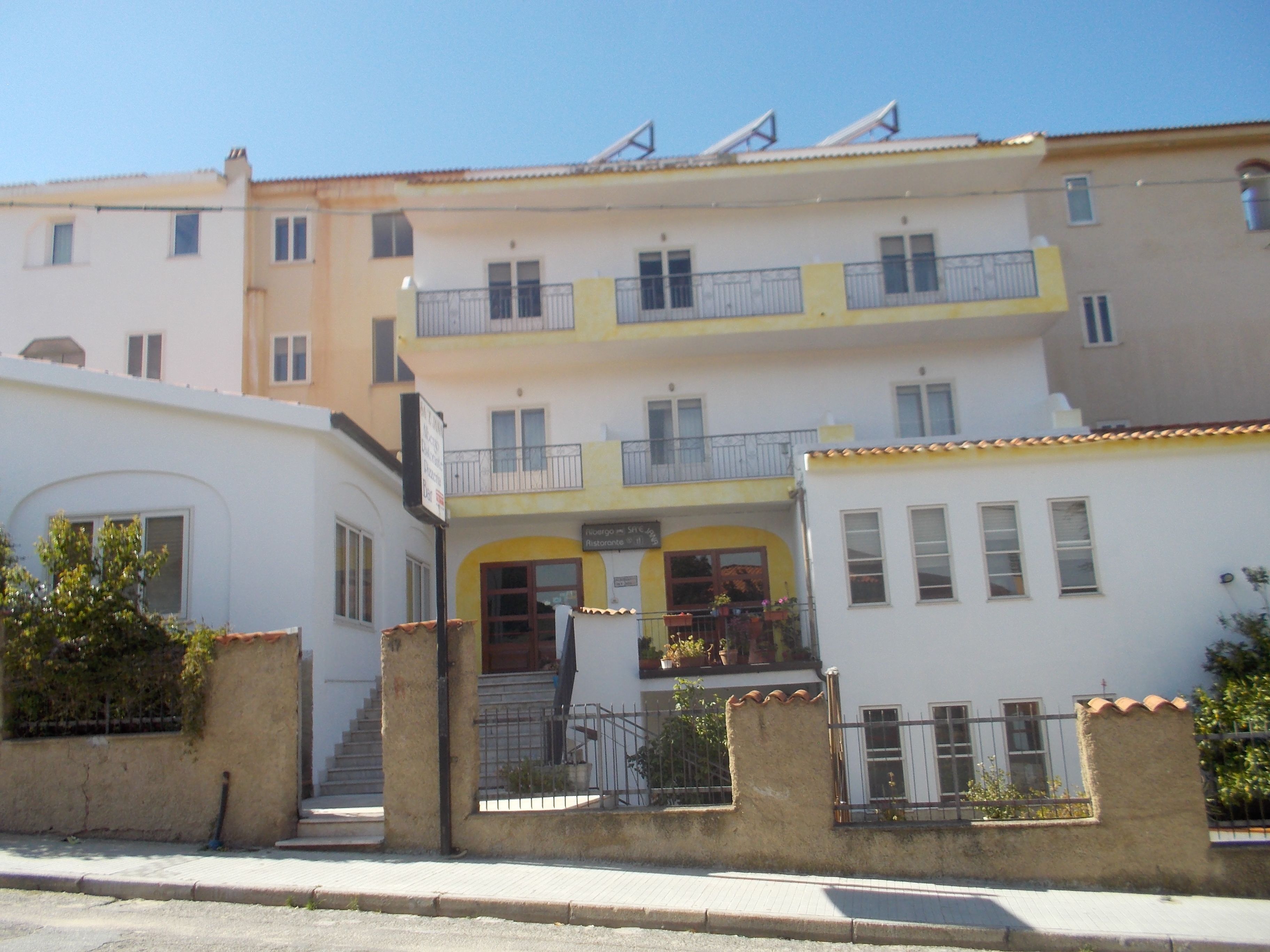 Um edifício de vários andares com um restaurante no andar térreo, apresentando uma escadaria que leva à entrada.