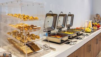 Buffet com diversos alimentos e utensílios.