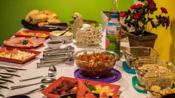 Uma mesa com diversos alimentos e utensílios, incluindo pão, frutas e uma tigela de nozes.
