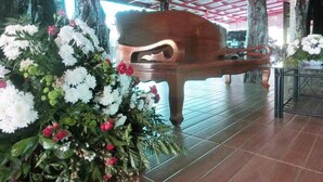 Um piano de cauda imponente numa sala ampla, com teto alto e grandes janelas.