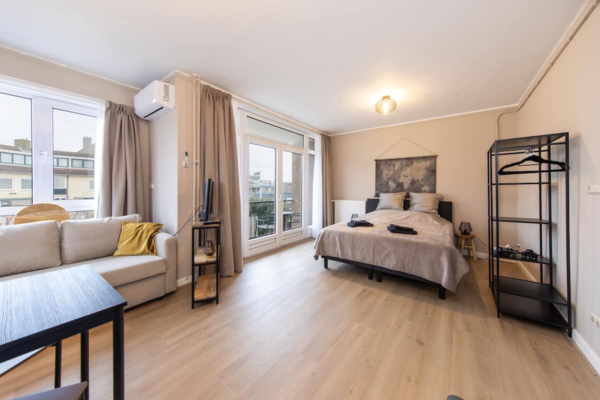 Um quarto moderno com uma cama, um sofá, uma mesinha e um guarda-roupa.