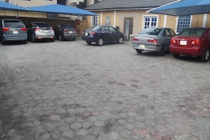 Uma área de estacionamento com vários carros estacionados sob toldos azuis.