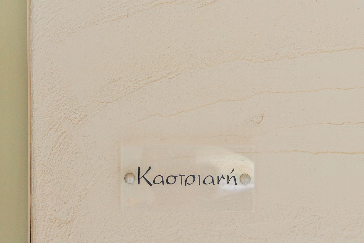 Pared bege texturizada com uma placa de metal que diz "Kaotiarno".