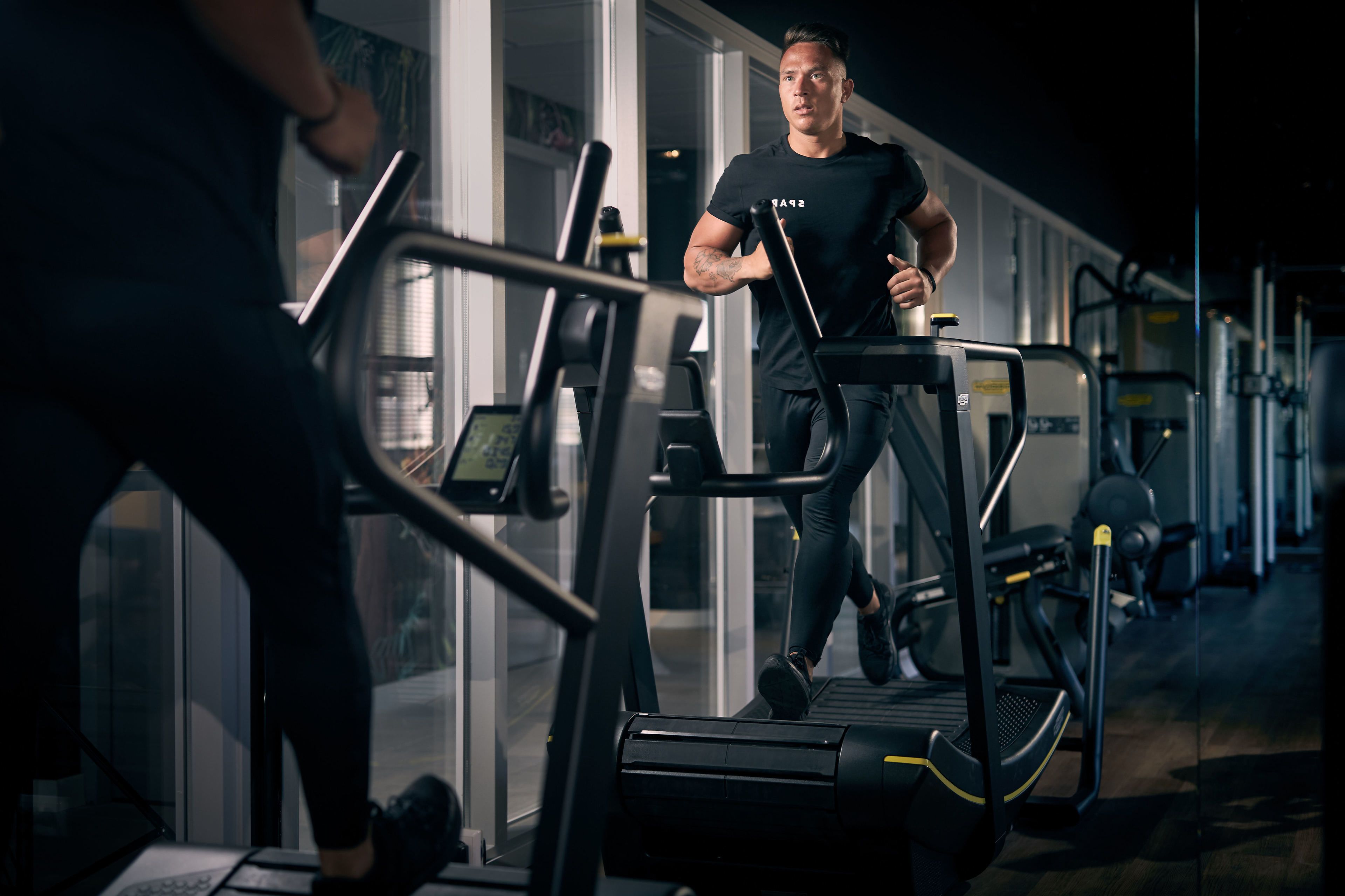 Uma academia com esteiras e equipamentos de exercícios.