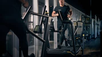 Uma academia com esteiras e equipamentos de exercícios.