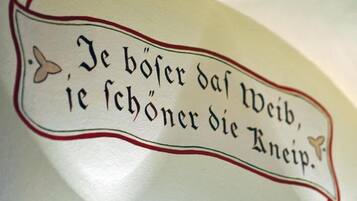 Um sinal decorativo com texto em alemão, com borda vermelha e um desenho de borboleta.