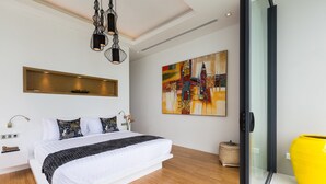 Quarto moderno com uma cama grande, piso de madeira, prateleira fixada na parede e uma grande pintura abstrata.