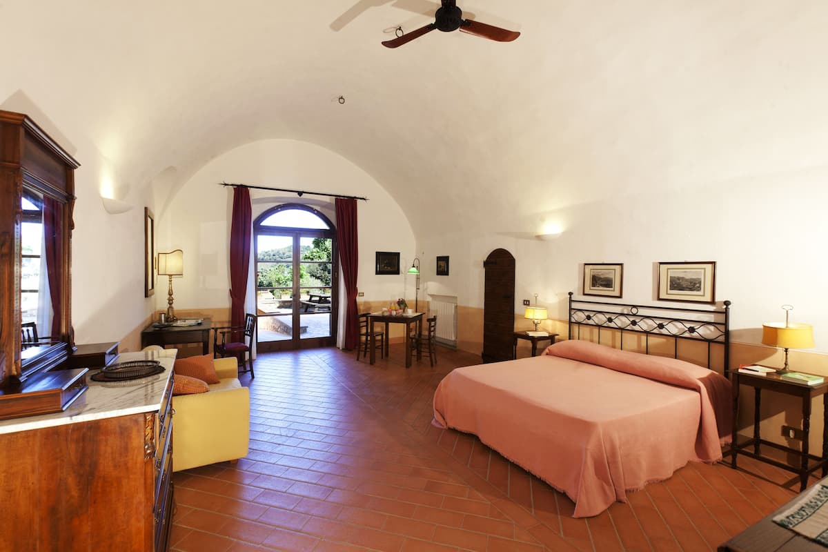 Um quarto espaçoso com uma cama grande, um espaço para refeições e uma cozinha.