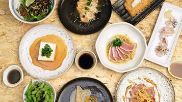 Diversos pratos, incluindo sushi, sashimi e uma tigela de edamame.