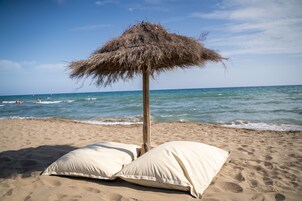 Praia particular, espreguiçadeiras, guarda-sóis, prática de windsurfe 