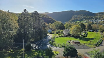 Zona residencial com casas, estrada e paisagem montanhosa.