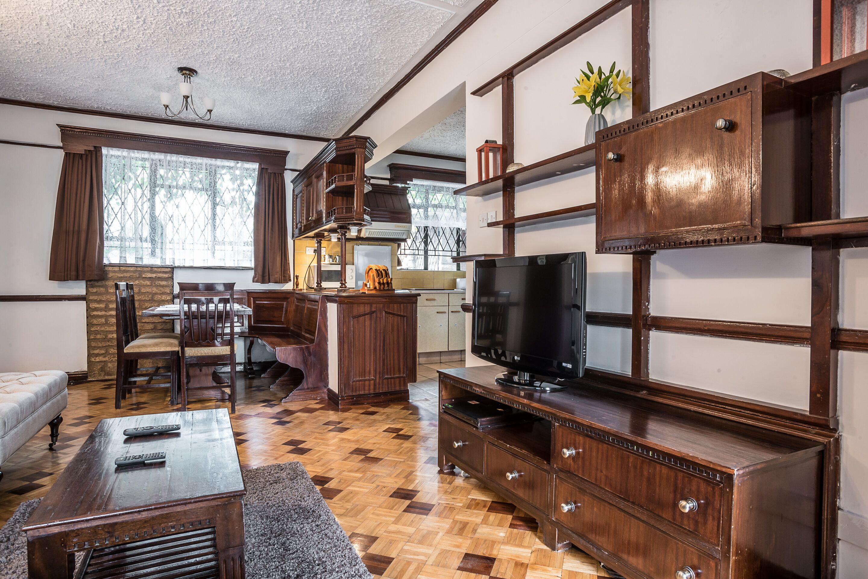 Uma sala de estar com televisão, móveis de madeira e lareira.