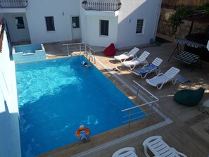 Piscina externa, guarda-sóis, espreguiçadeiras