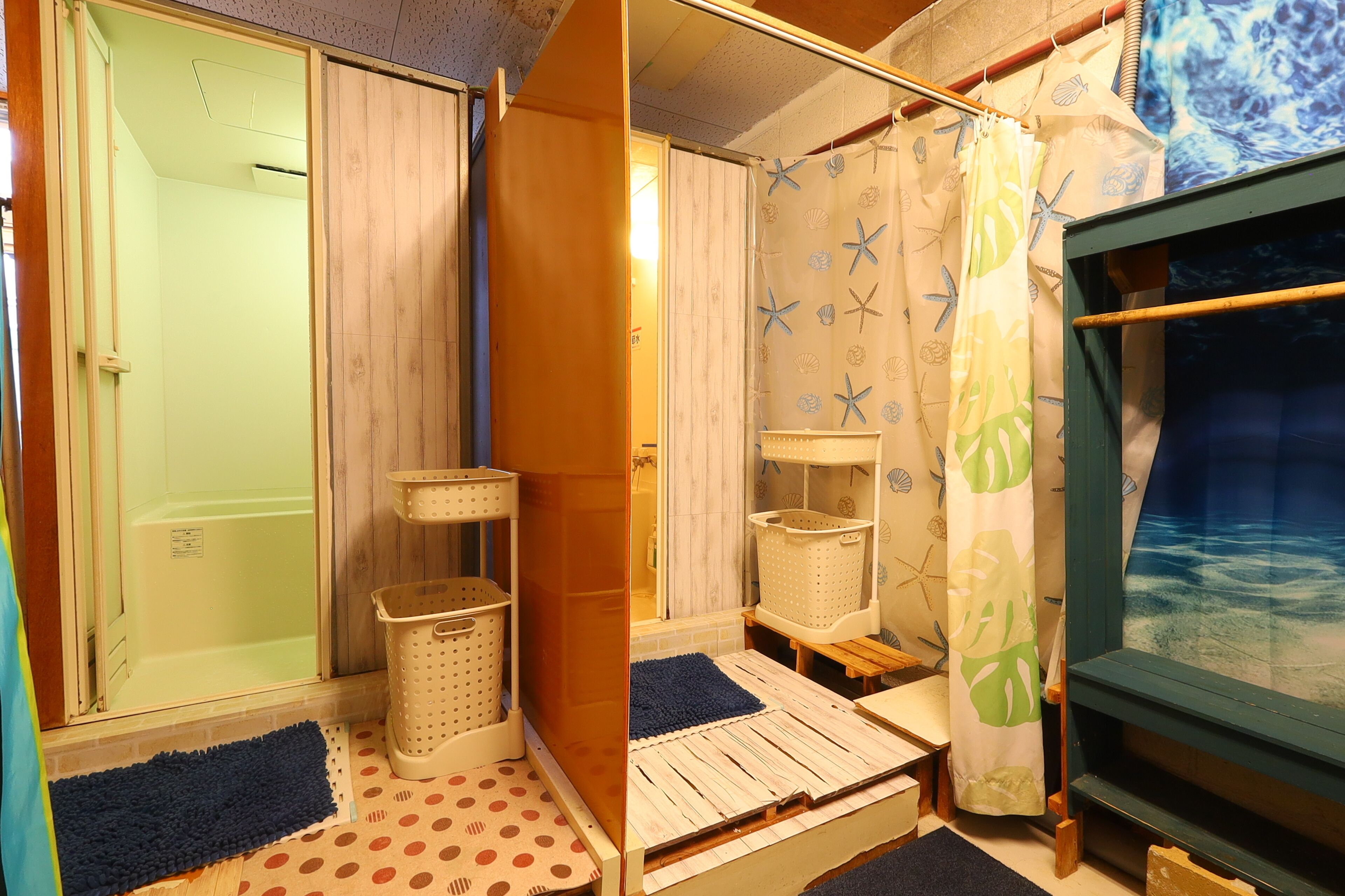 Quarto compacto com chuveiro, um pequeno espaço para sentar, televisão e janela com vista.