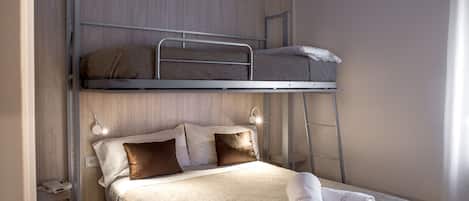 Uma cama beliche com uma cama de baixo e um beliche superior. Há uma toalha dobrada na cama de baixo.