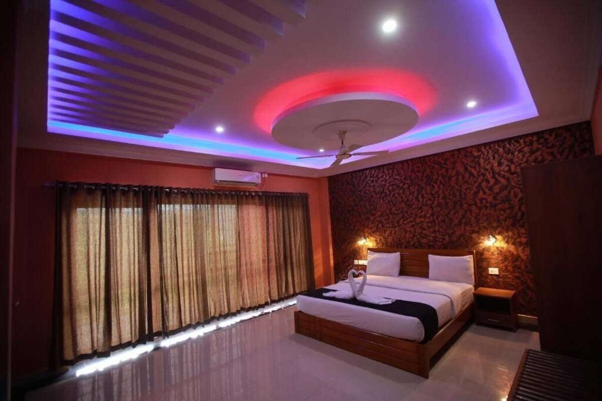 Quarto de hotel moderno com cama, ventoinha no teto e ar condicionado fixado na parede.