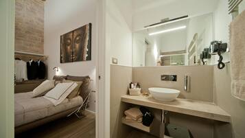 Quarto moderno com uma cama, uma mesinha de cabeceira e um espelho grande.