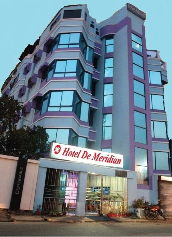 Um edifício moderno de hotel com uma placa que diz 'Hotel De Meridian'.