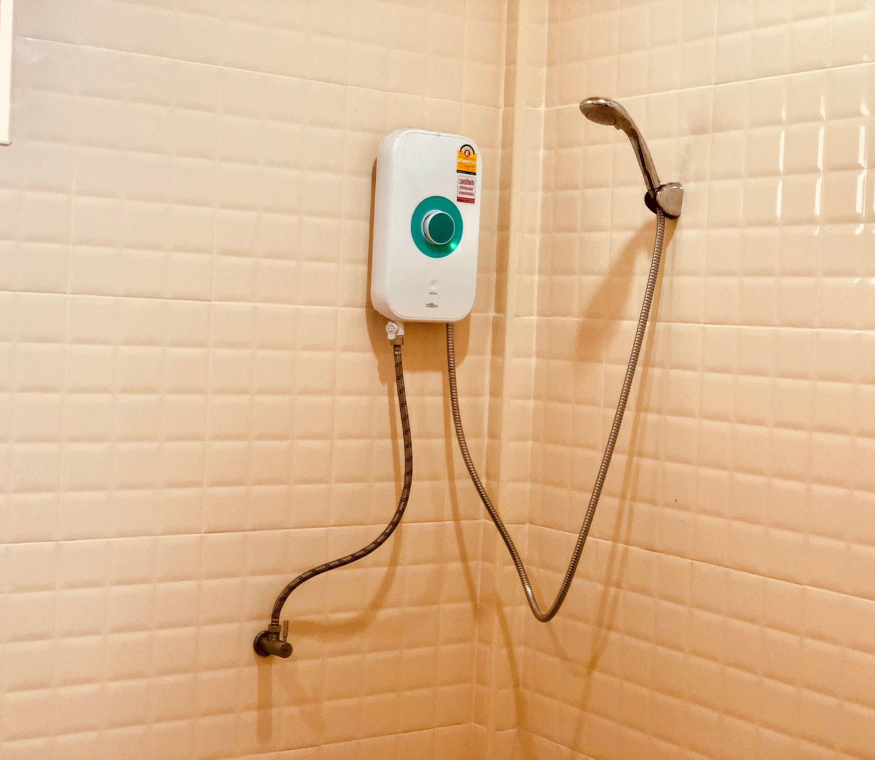 Chuveiro com chuveiro manual e painel de controle fixado na parede.