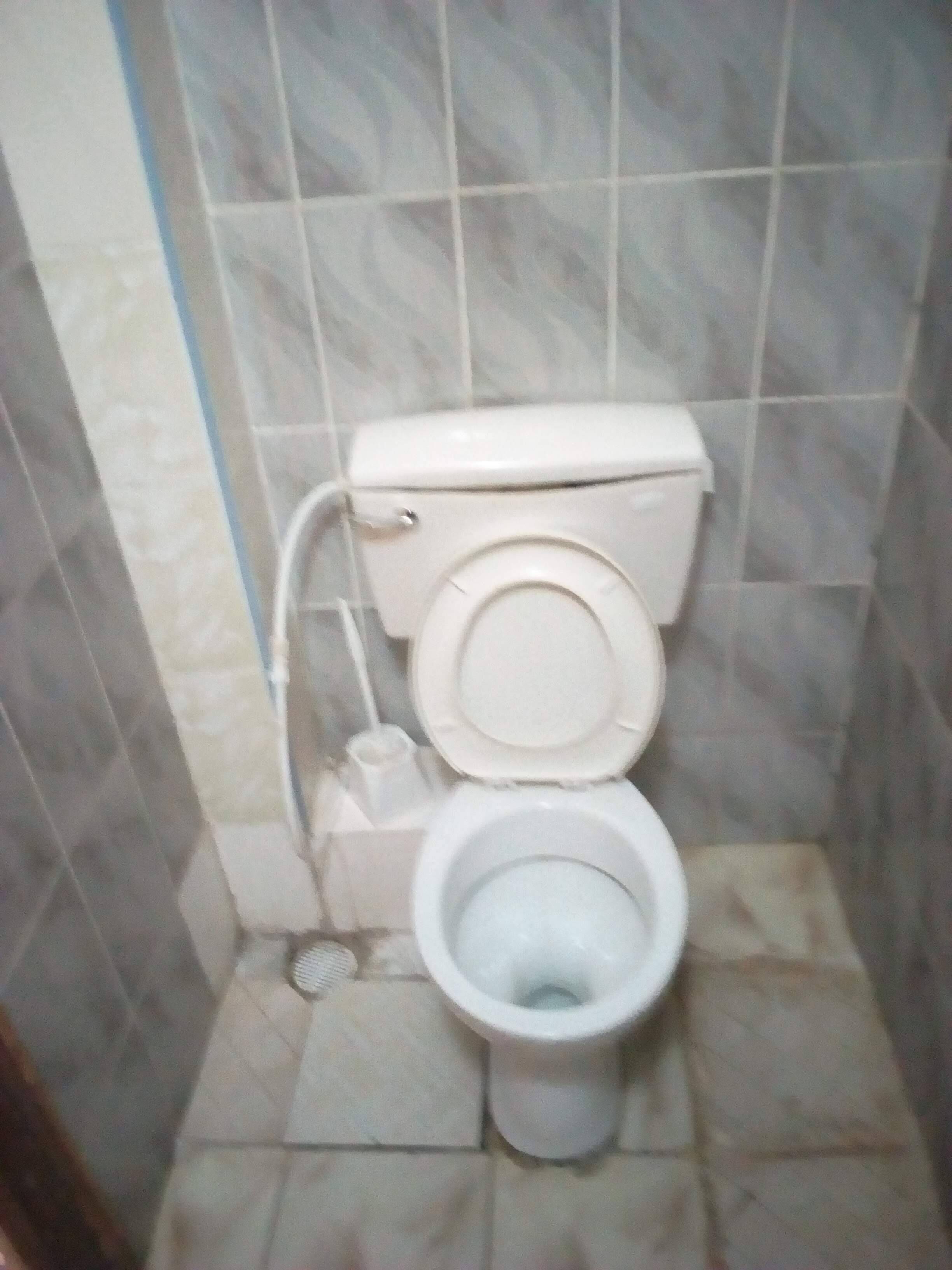 Casa de banho com sanita, bidé e secador de mãos embutido na parede.