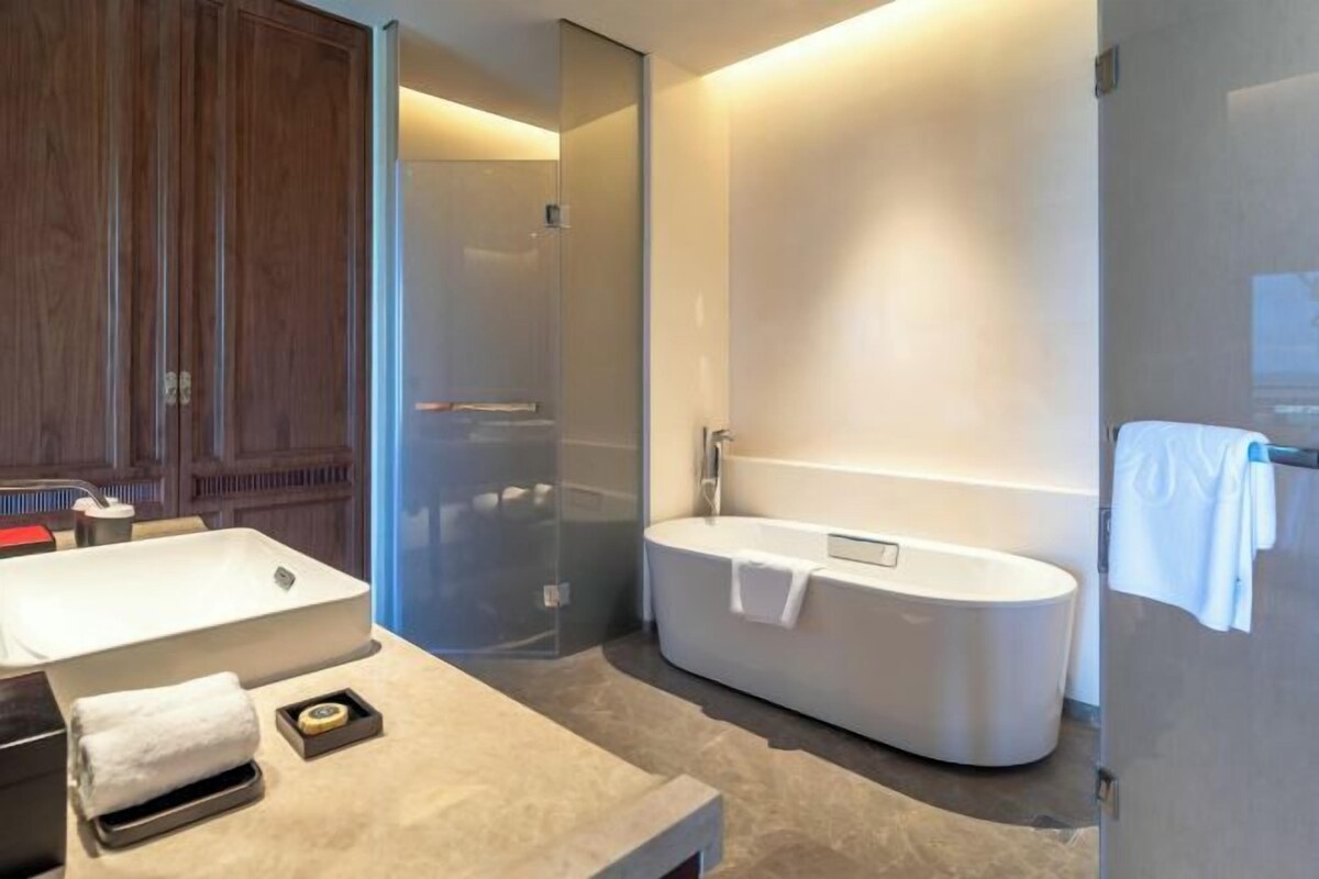 Uma casa de banho moderna com uma banheira grande, área de duche separada e toucador com lavatório e espelho.