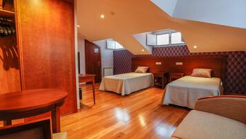 Quarto com duas camas, móveis de madeira e claraboia.